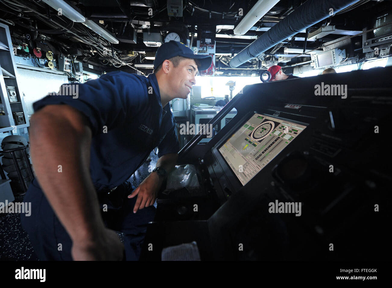 Seaman Apprentice John Sedillo stands watch as helmsman aboard the USS ...