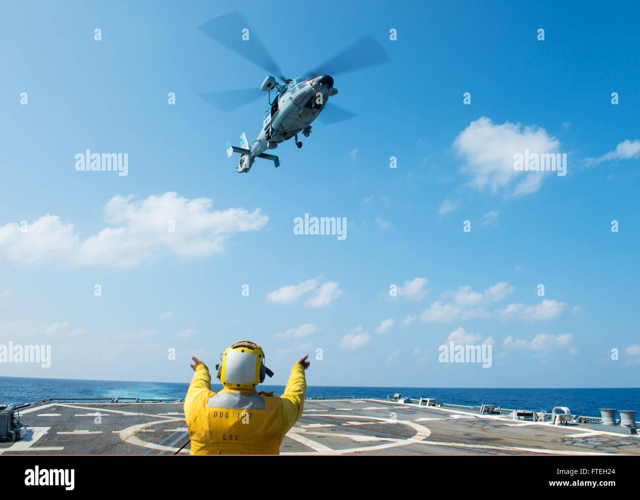 A U.S. Navy Boatswain's Mate signals to an Israeli Eurocopter AS565 MA ...