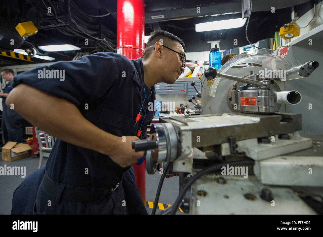 Machinist Repairman 3rd Class Achibald Salcedo is seen adjusting a ...
