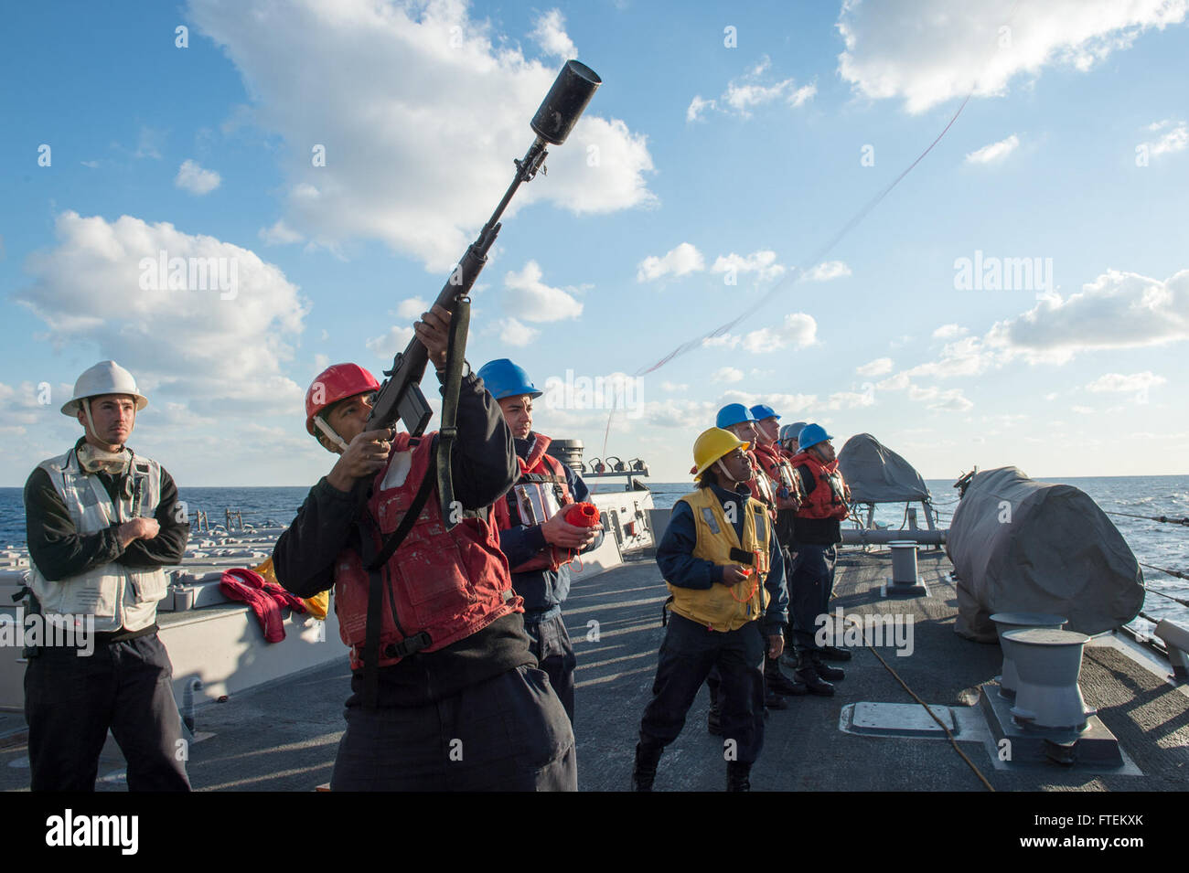 A sailor aboard USS Donald Cook (DDG 75) fires a line to the ...