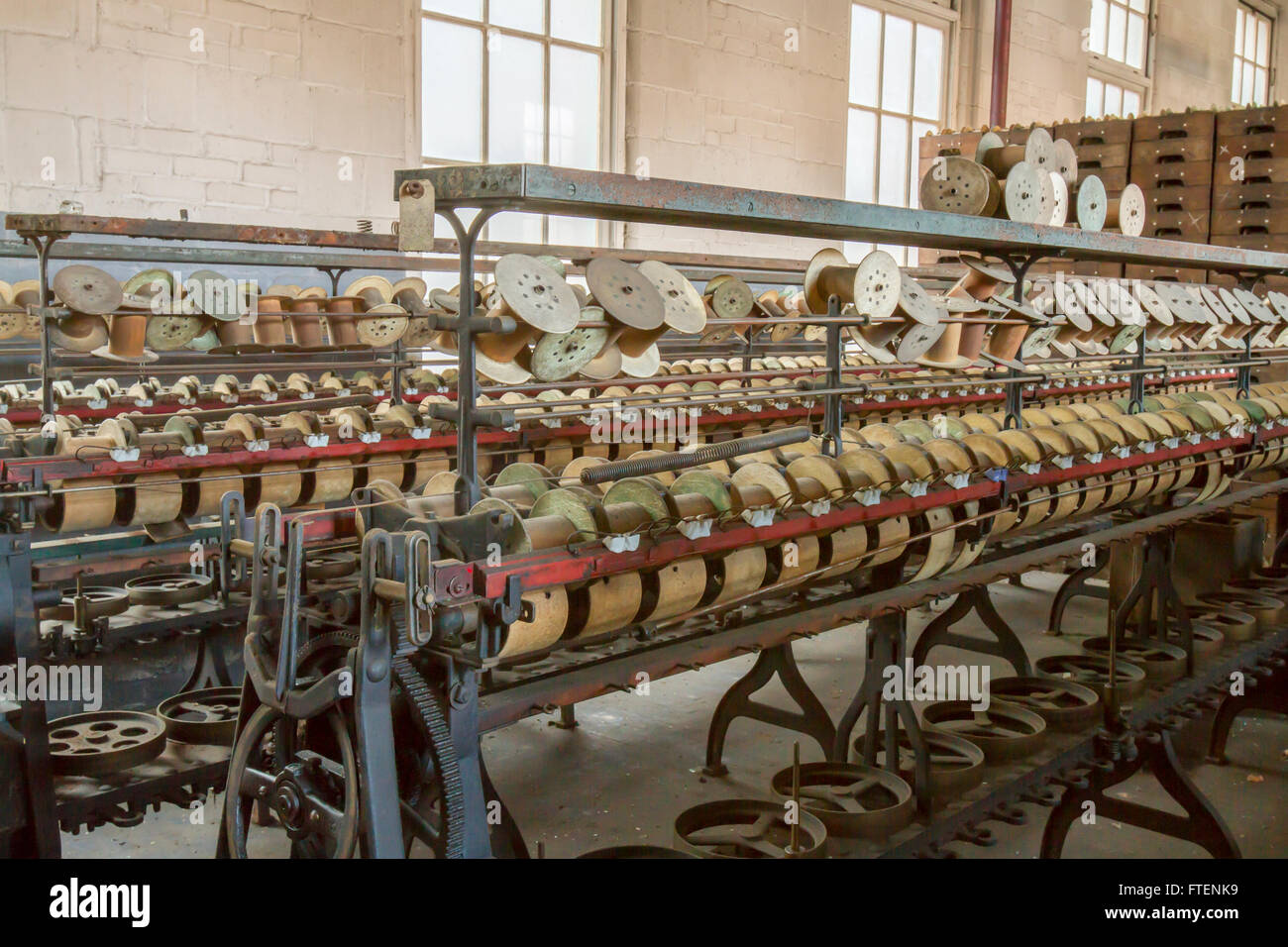 Empty thread spools on antique machinery in turn of the century silk ...