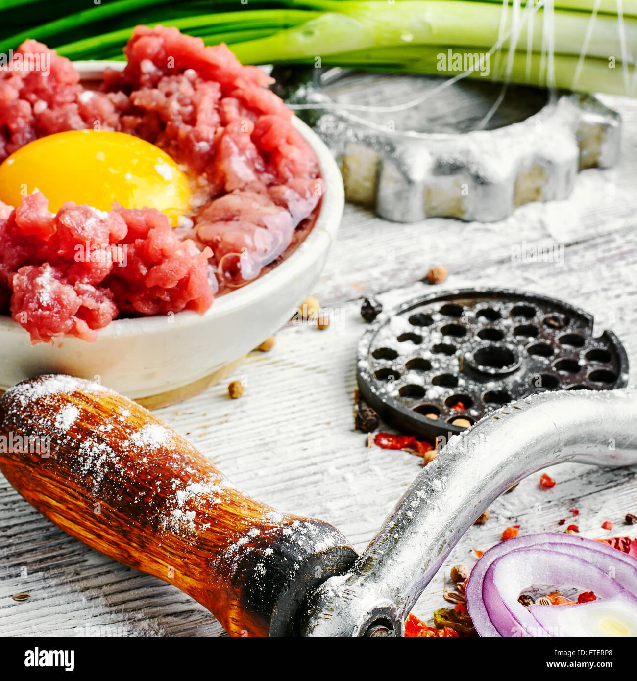 Dish of raw minced beef meat and parts of meat grinder Stock Photo - Alamy