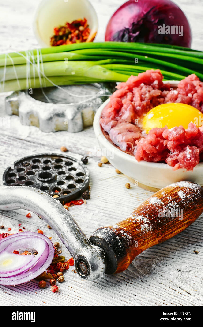 Dish of raw minced beef meat and parts of meat grinder Stock Photo - Alamy
