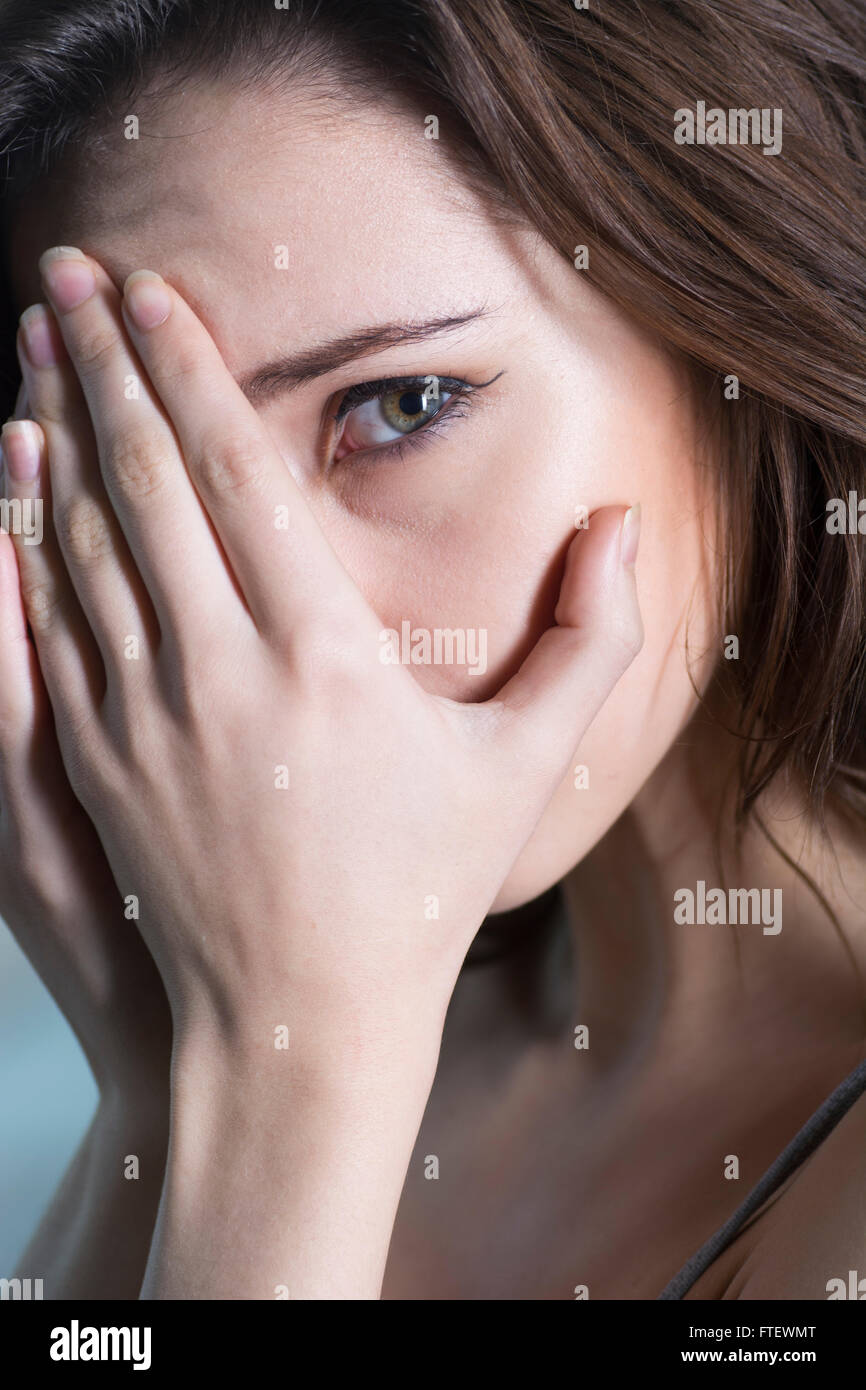 Young woman hiding face with hands Stock Photo - Alamy