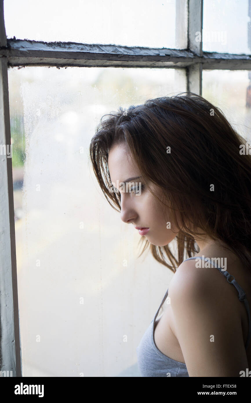 Profile of a beautiful young woman looking out of the window Stock ...
