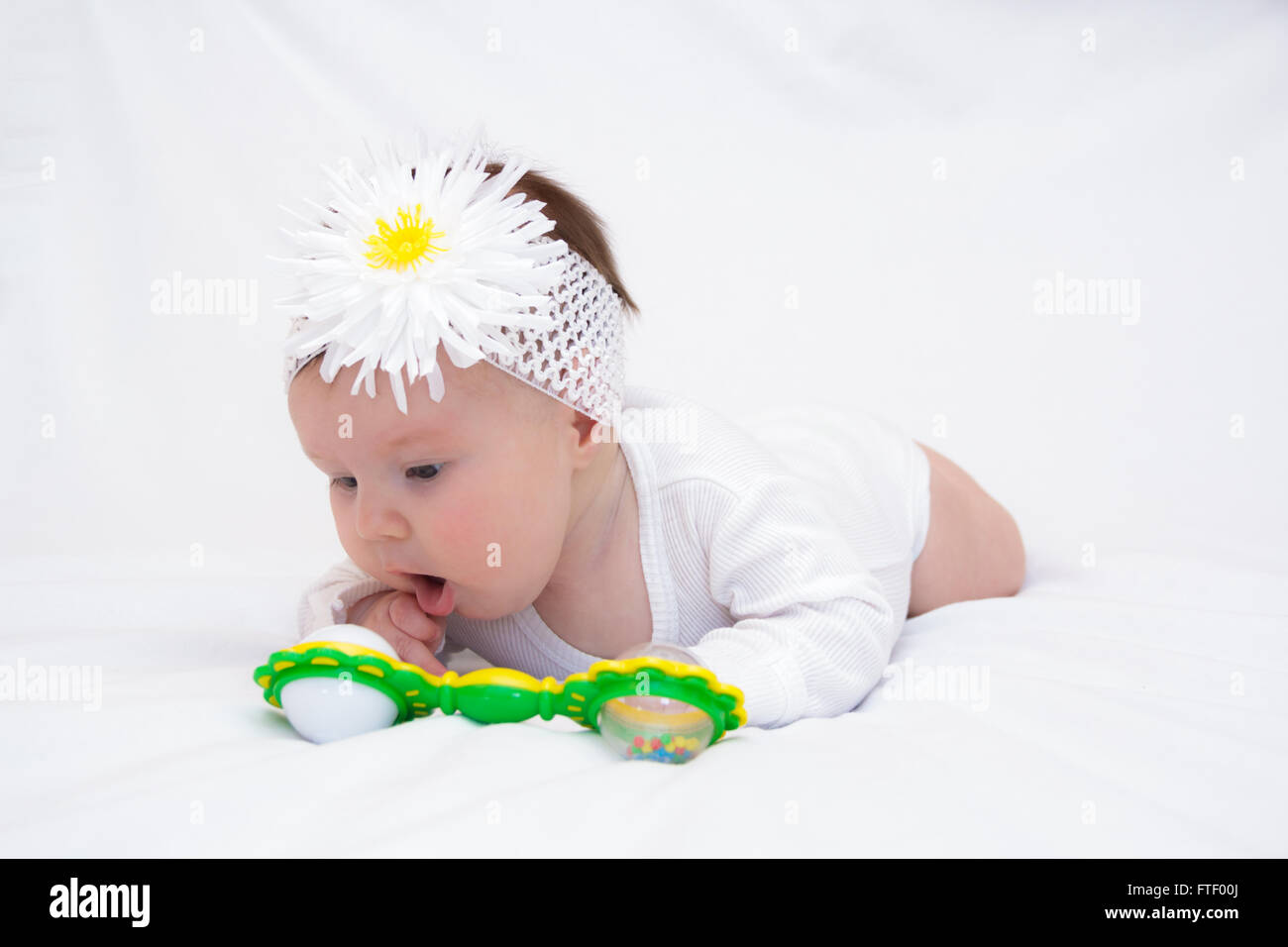 little girl lying and playing with a rattle Stock Photo - Alamy