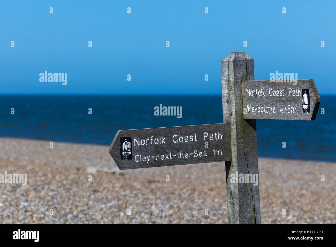 A wooden sign post captured in front of the North Sea & the shingle on ...