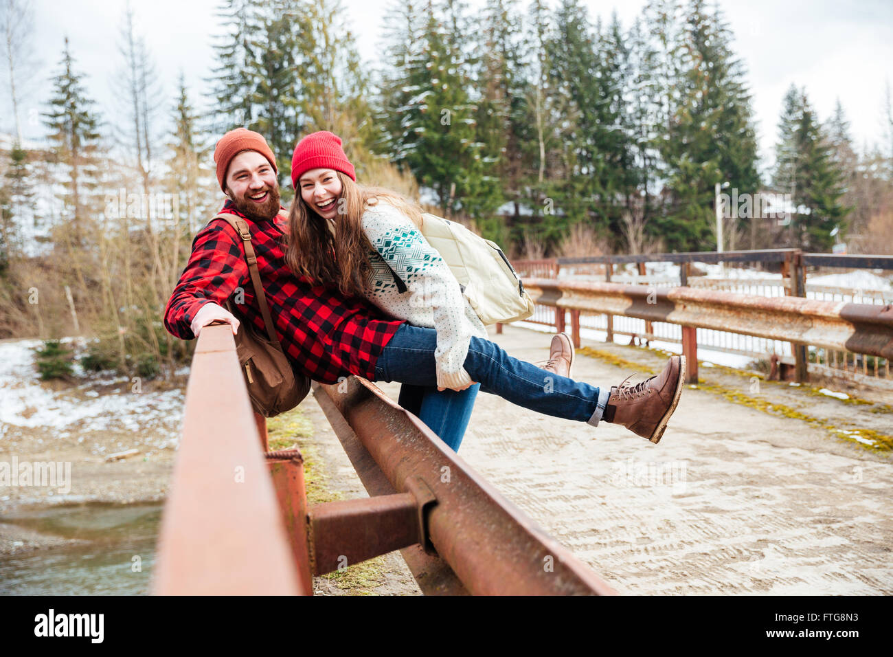Happy young couple sitting on old bridge and having fun Stock Photo - Alamy