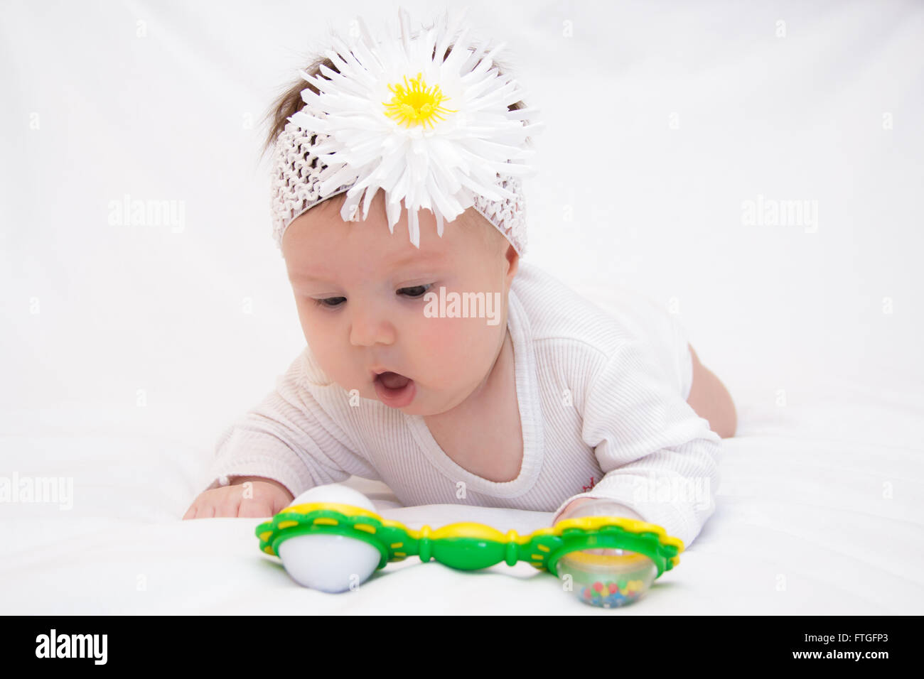 little girl lying and playing with a rattle Stock Photo - Alamy