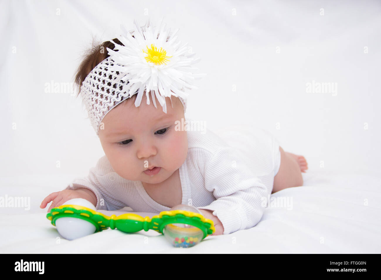 little girl lying and playing with a rattle Stock Photo - Alamy