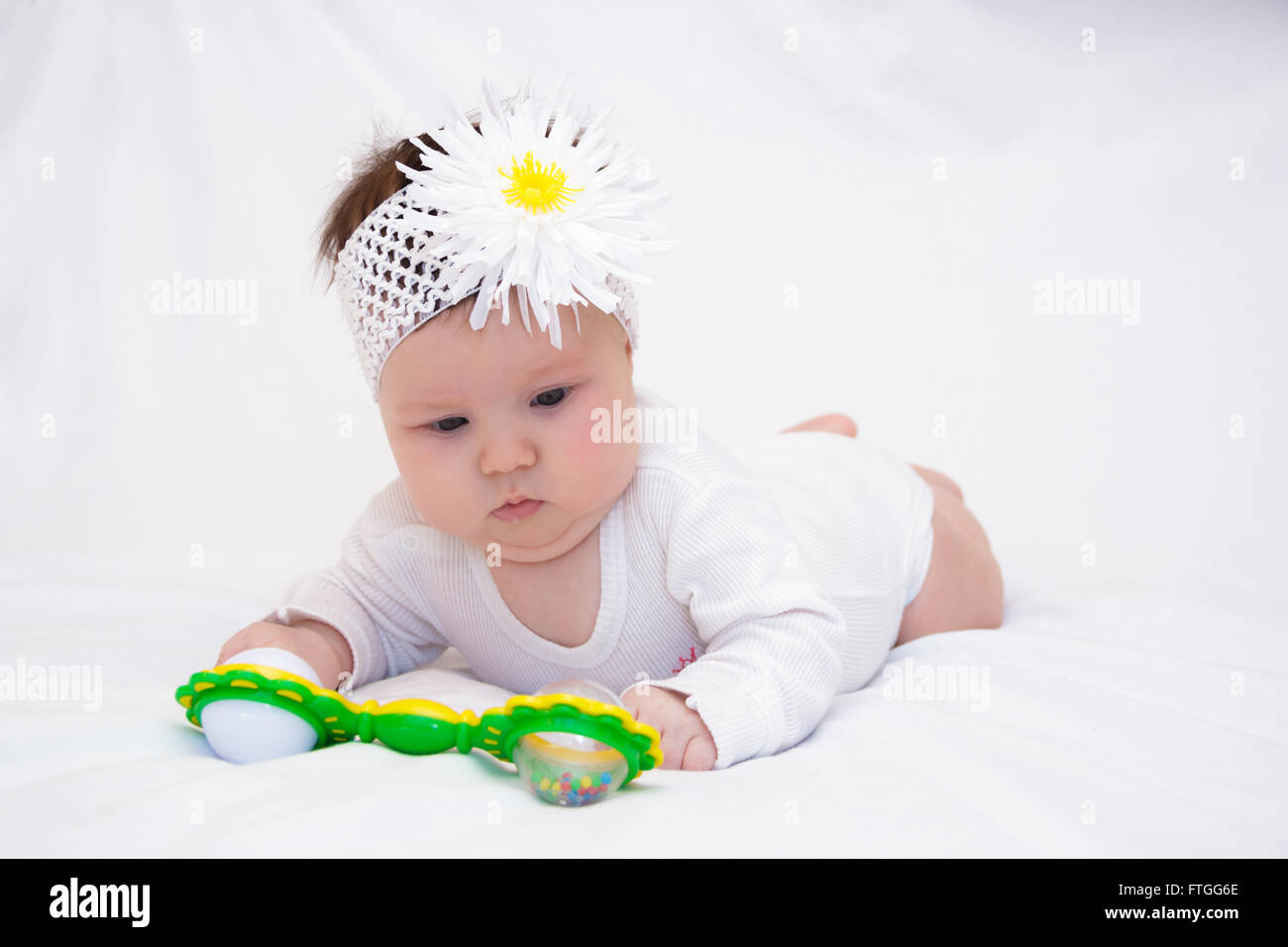 little girl lying and playing with a rattle Stock Photo - Alamy