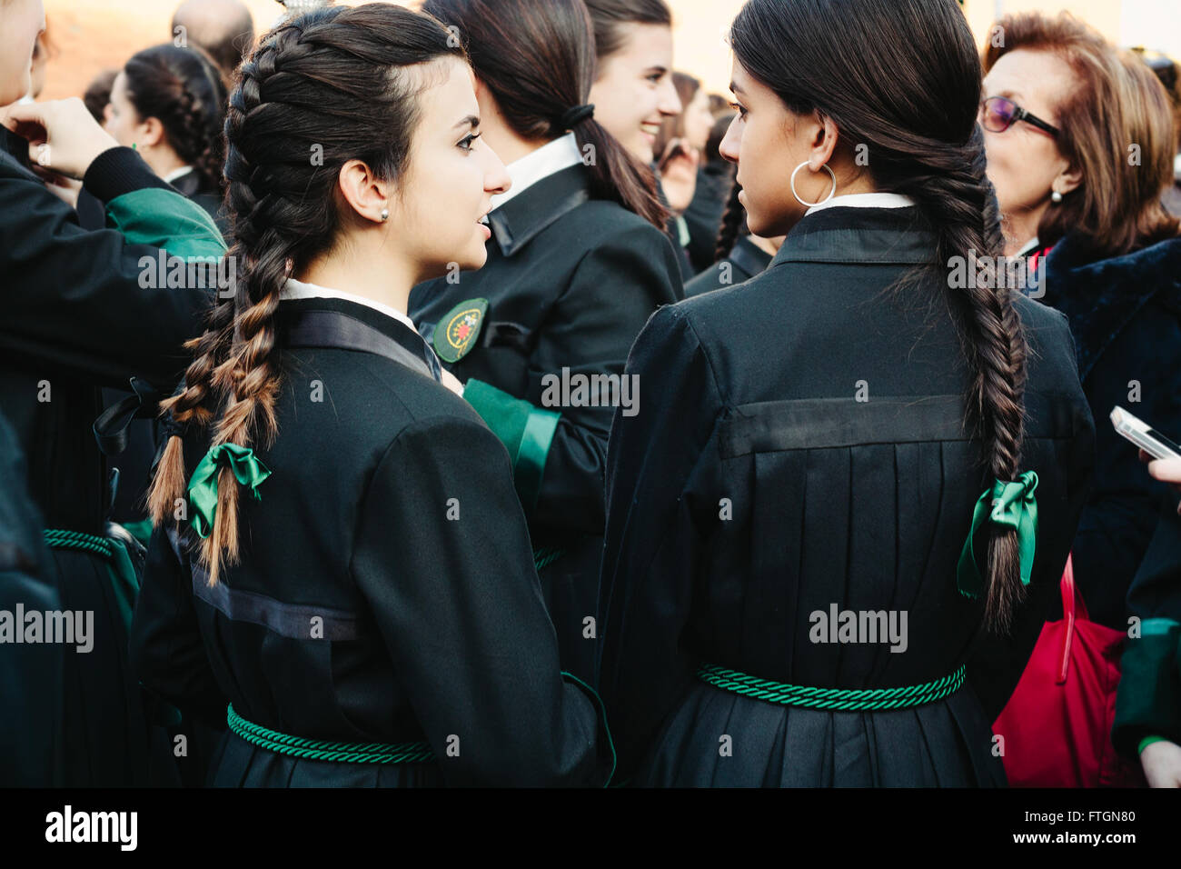 Two girls talking surrounded by people before the procession. Semana ...