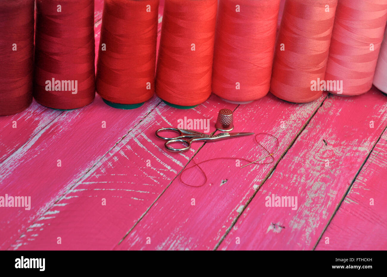 Scissors and needle for sewing and embroidery, threads of red and pink ...