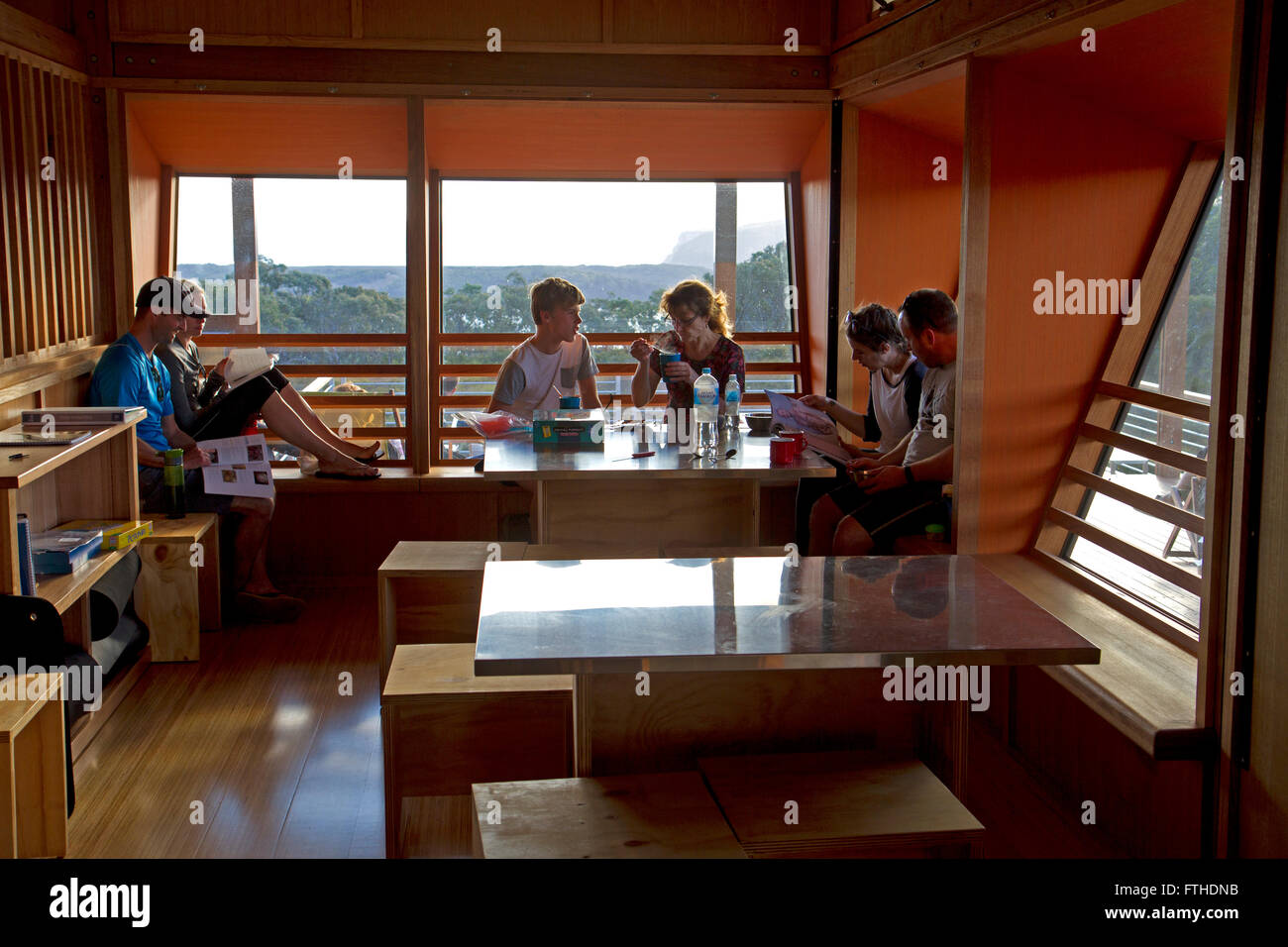 Hikers inside Surveyors, the first hut along the Three Capes Track ...