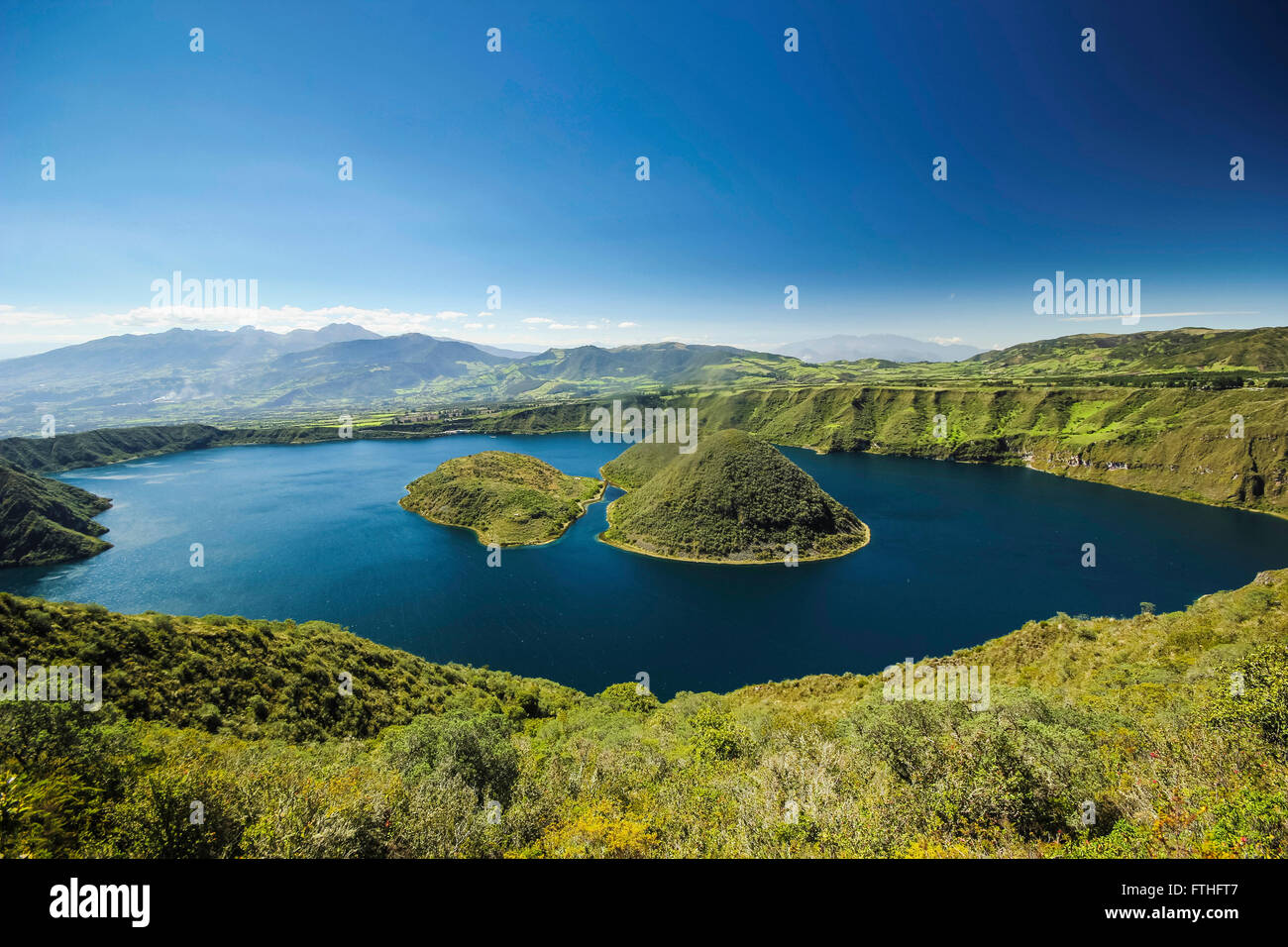 blue volcanic crater lake with two islands at daylight in ecuador Stock ...