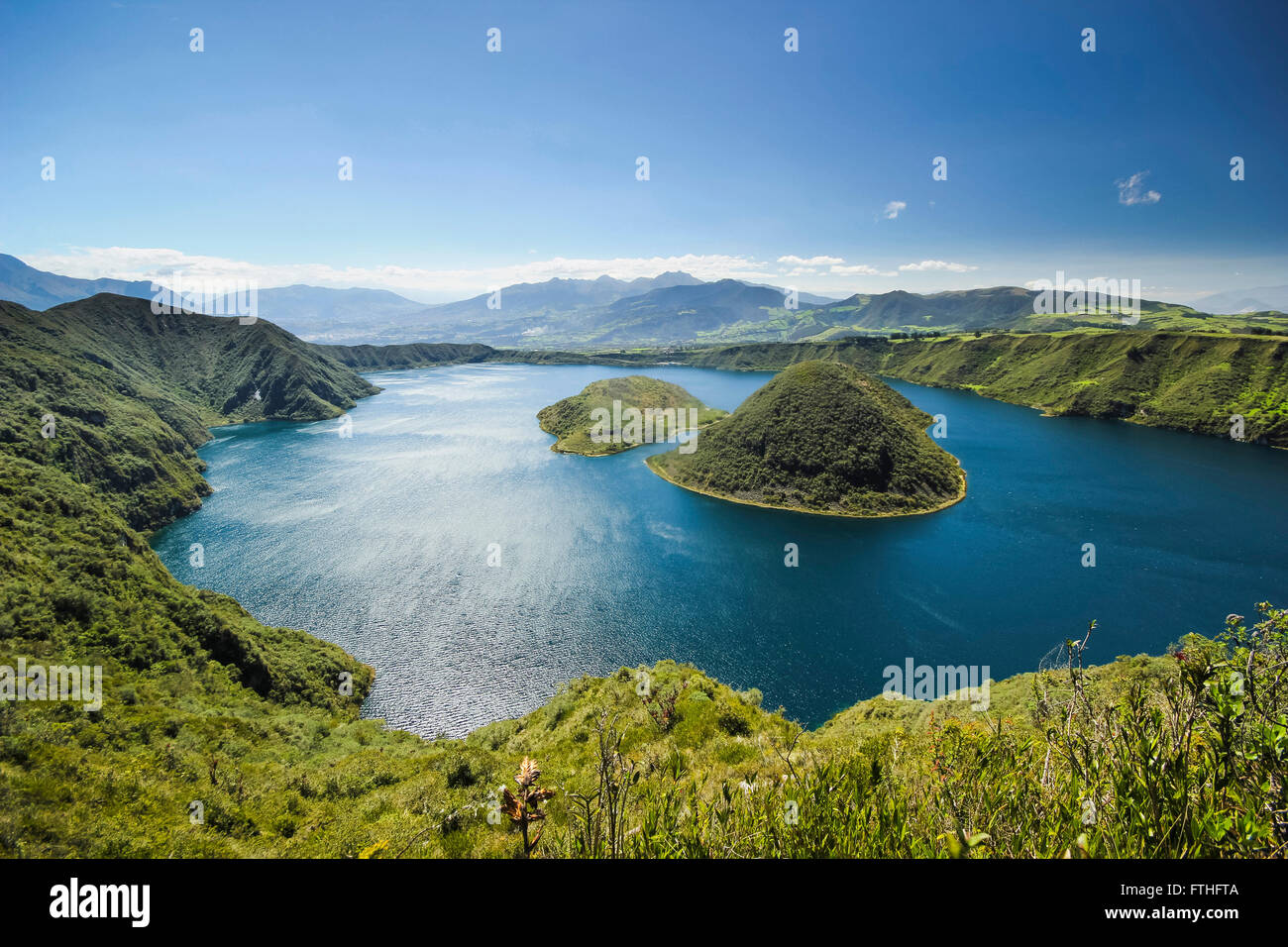 blue volcanic crater lake with two islands at daylight in ecuador Stock ...