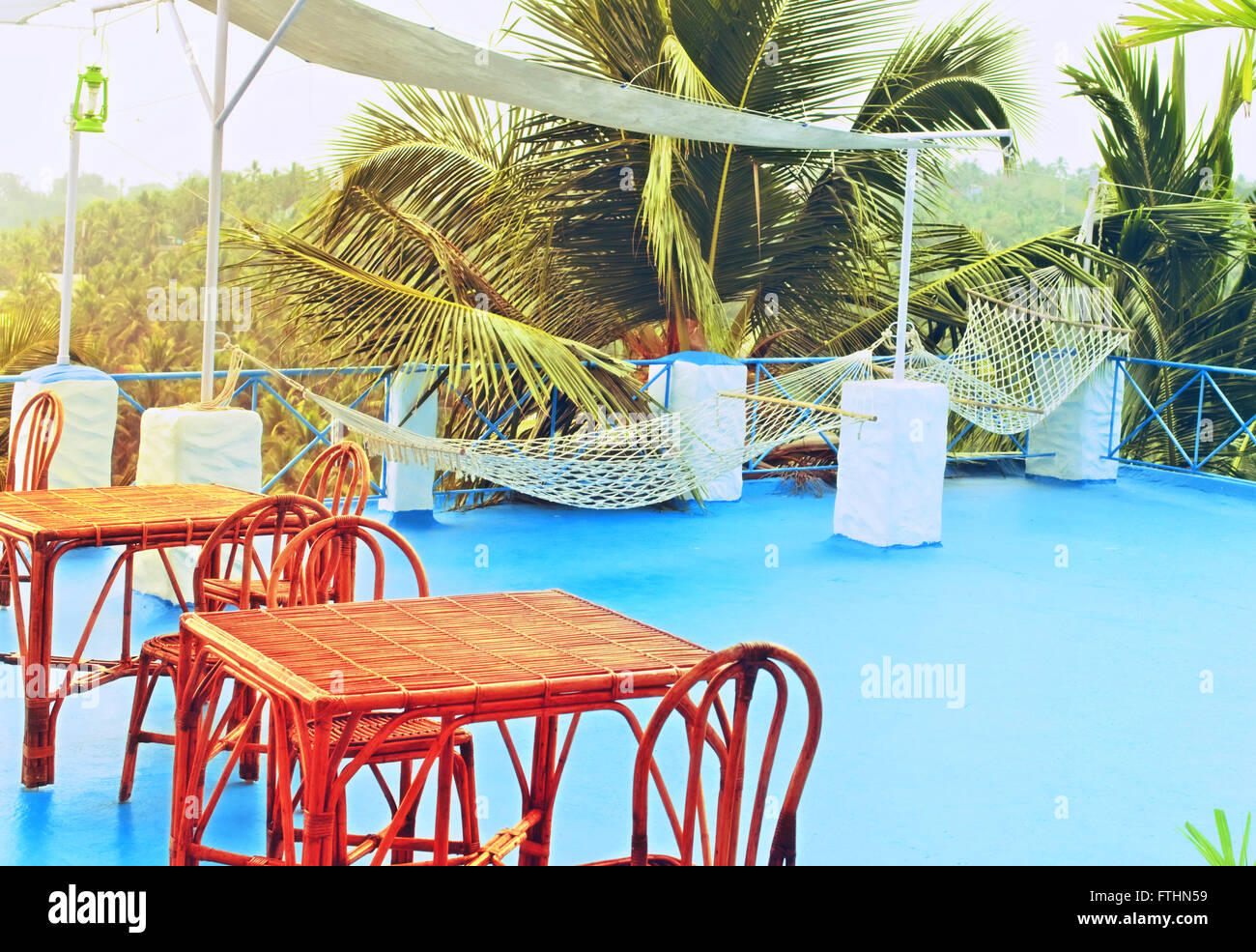 Interior of the cafe on veranda against backdrop of tropical forest ...