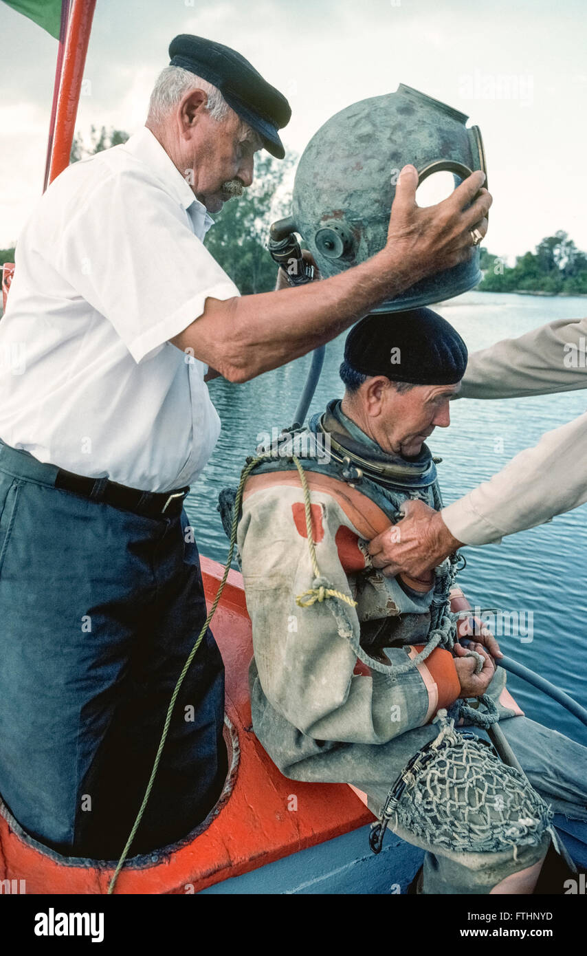 A veteran sponge diver is fitted with a traditional hard-hat bell ...