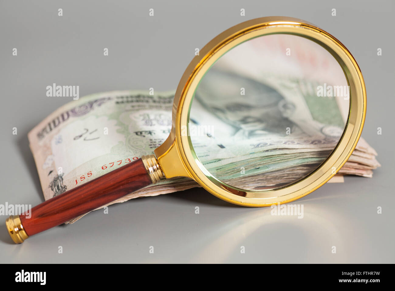 Indian Currency Rupee Notes with magnifying glass on gray Stock Photo ...