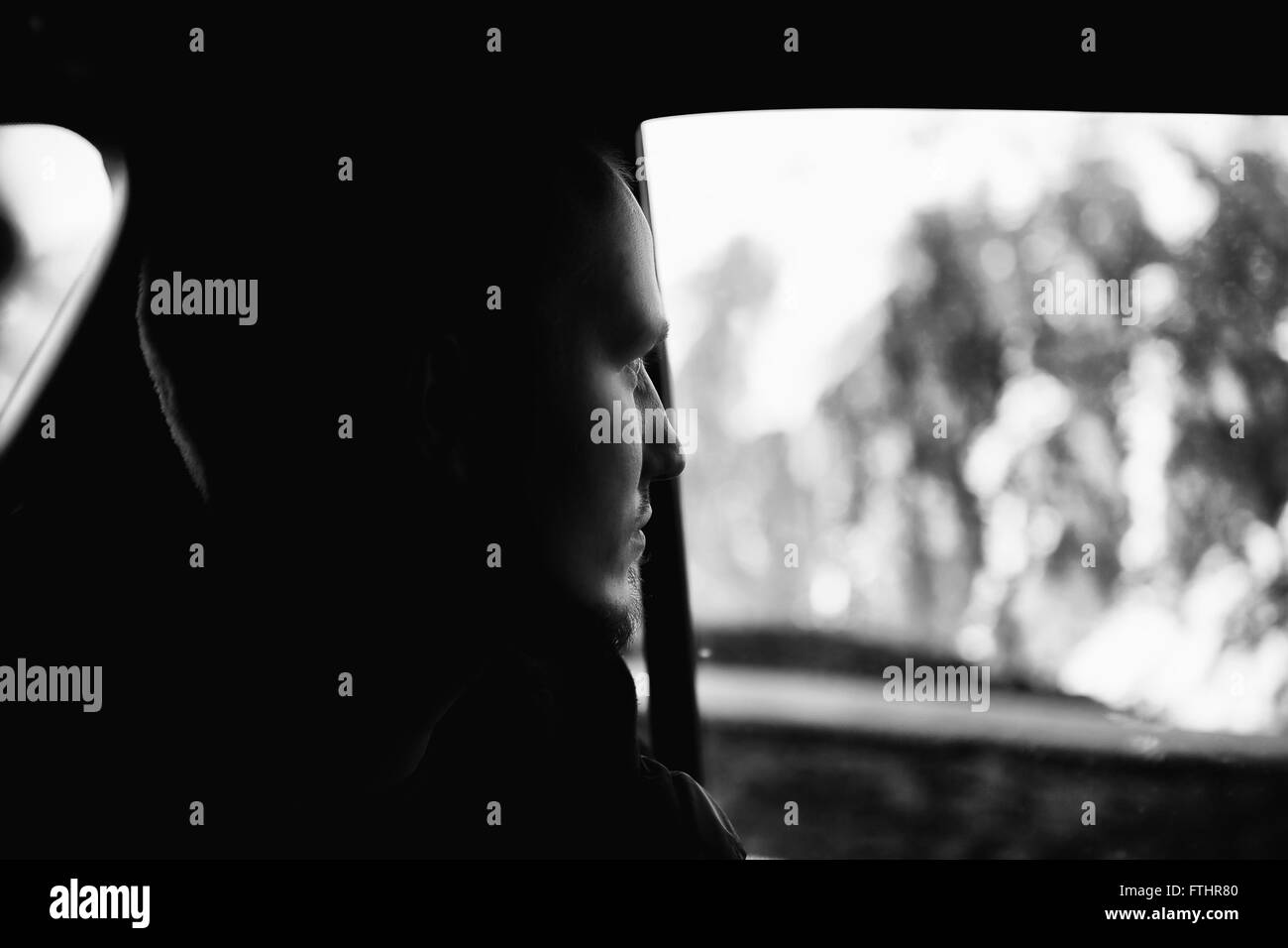Portrait of man looking out the car window Stock Photo - Alamy