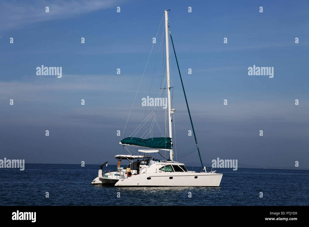 Small white yaht in blue ocean Stock Photo - Alamy