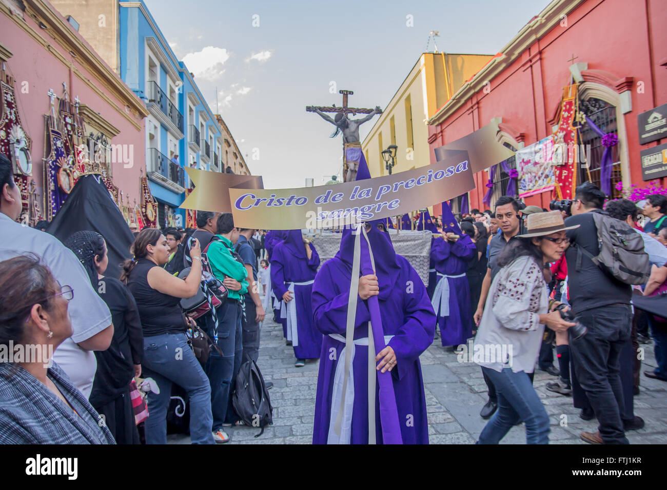 People at the Holy Friday procession in Oaxaca, Mexico. The placard ...