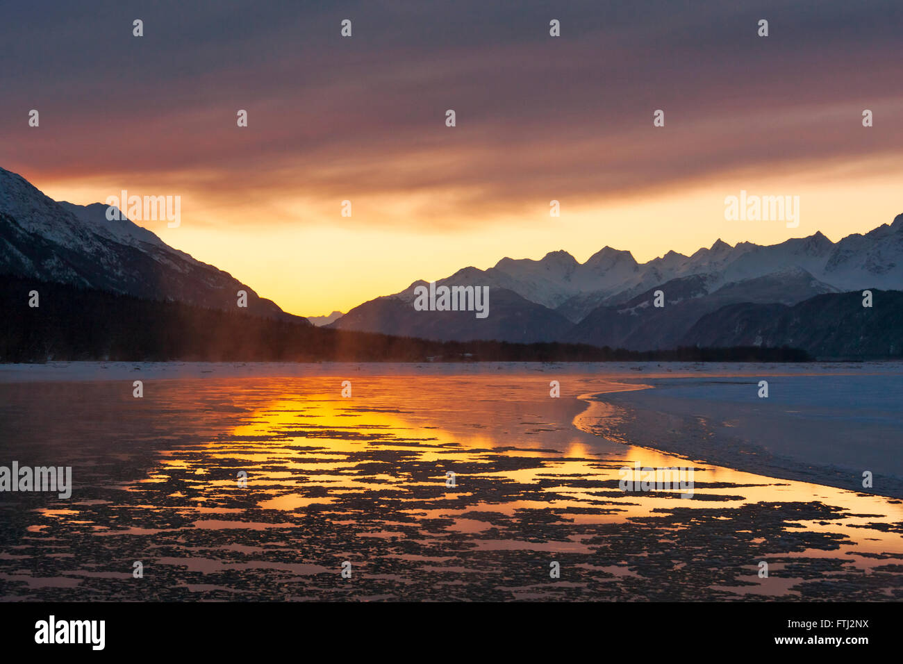 Landscape of river and mountain covered with snow at sunset, Haines ...