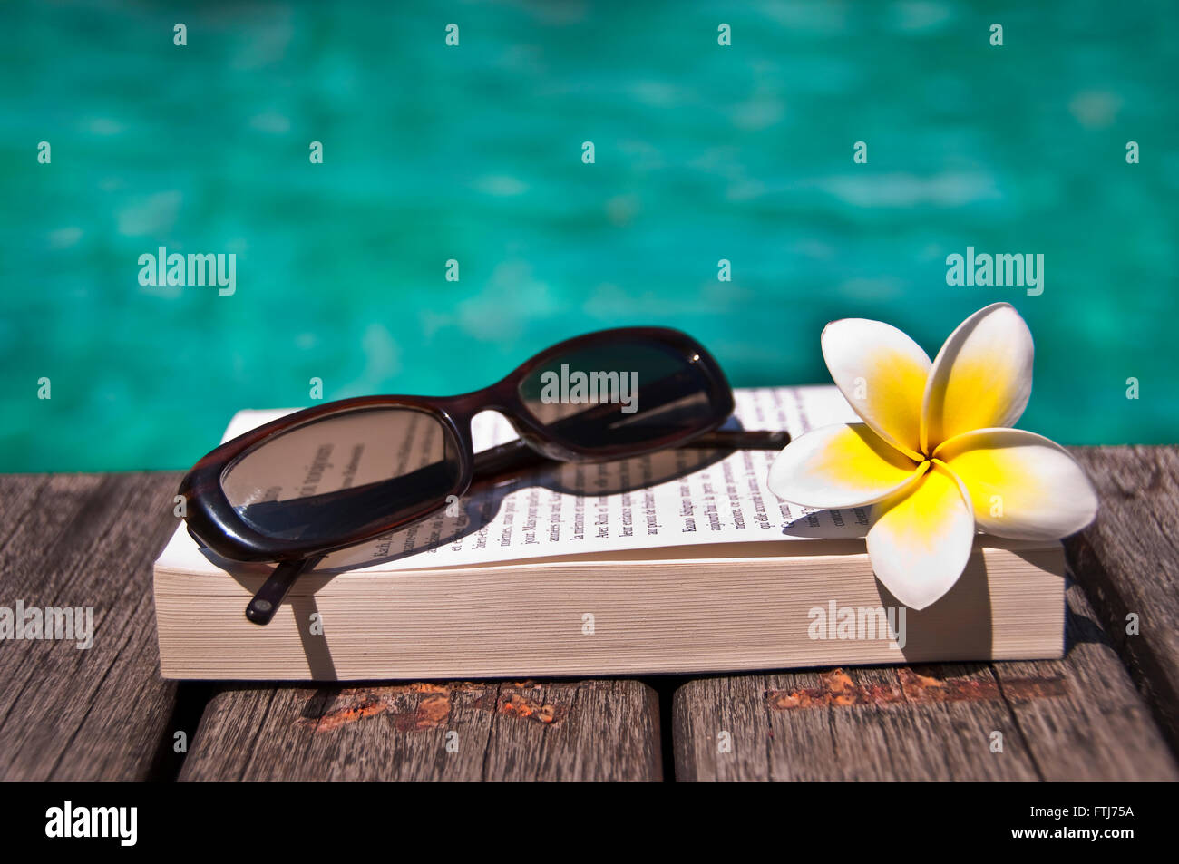 Book and sunglasses, blue water background Stock Photo - Alamy