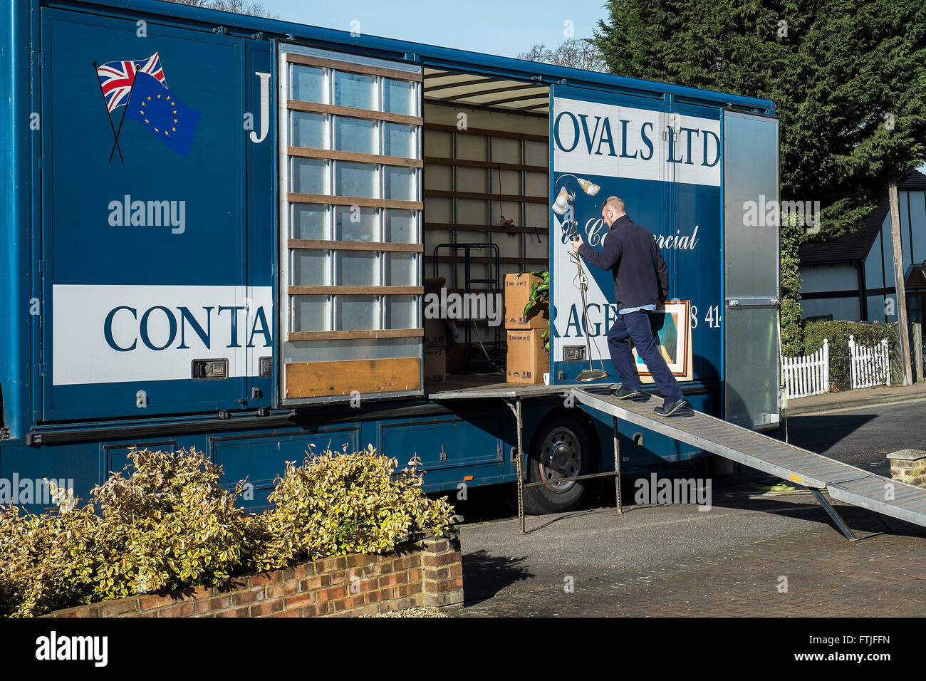A removal man loads household items into a removal van Stock Photo - Alamy