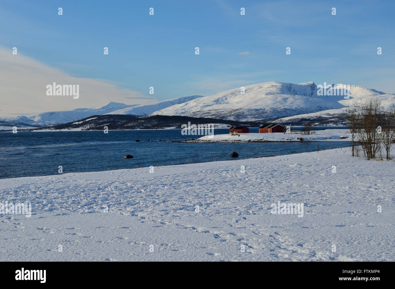 blue sea with snowy sea shore and mountain with red huts Stock Photo ...