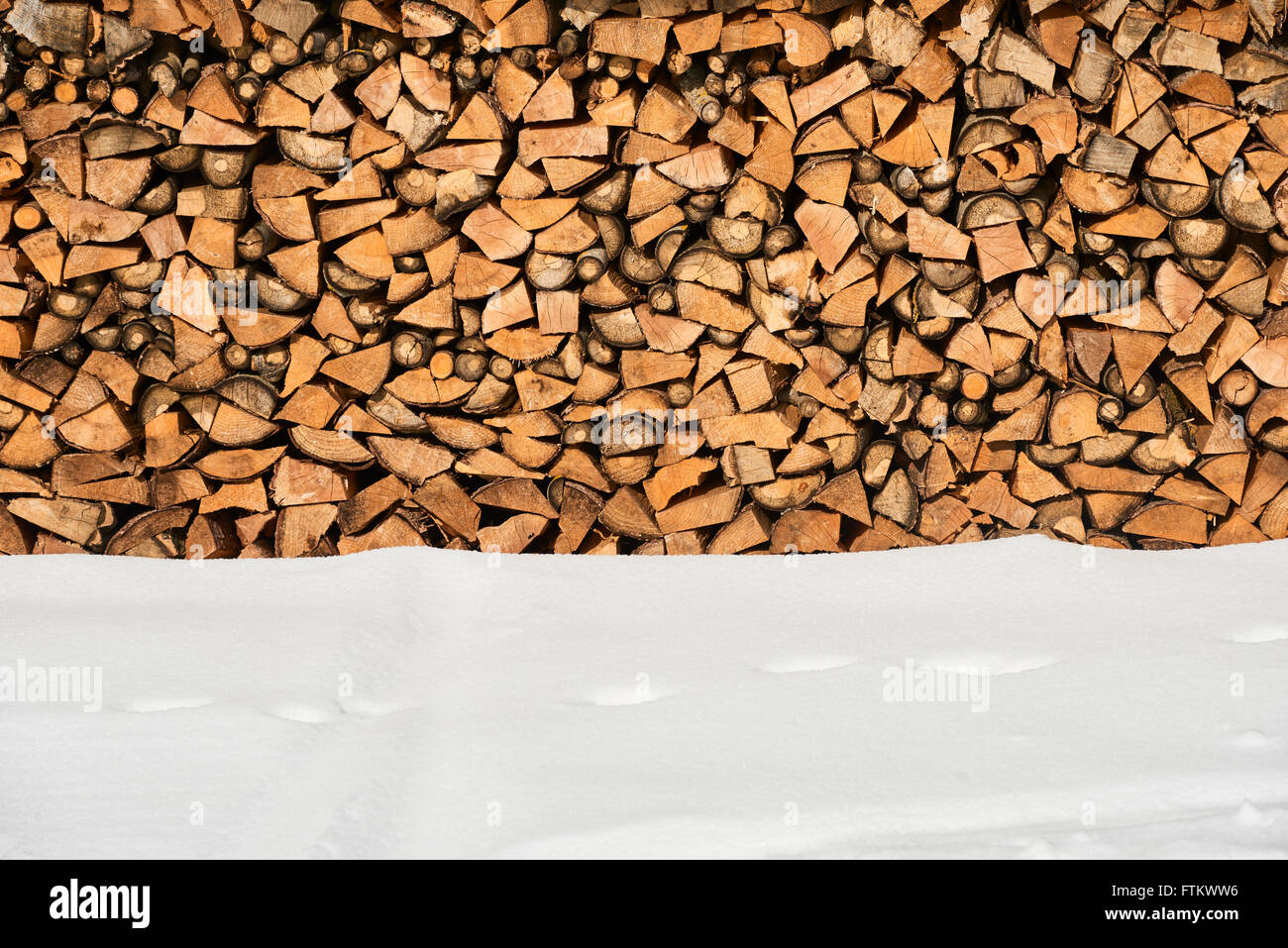 Firewood stacked in winter. Wood pile with snow stacked for firewood ...