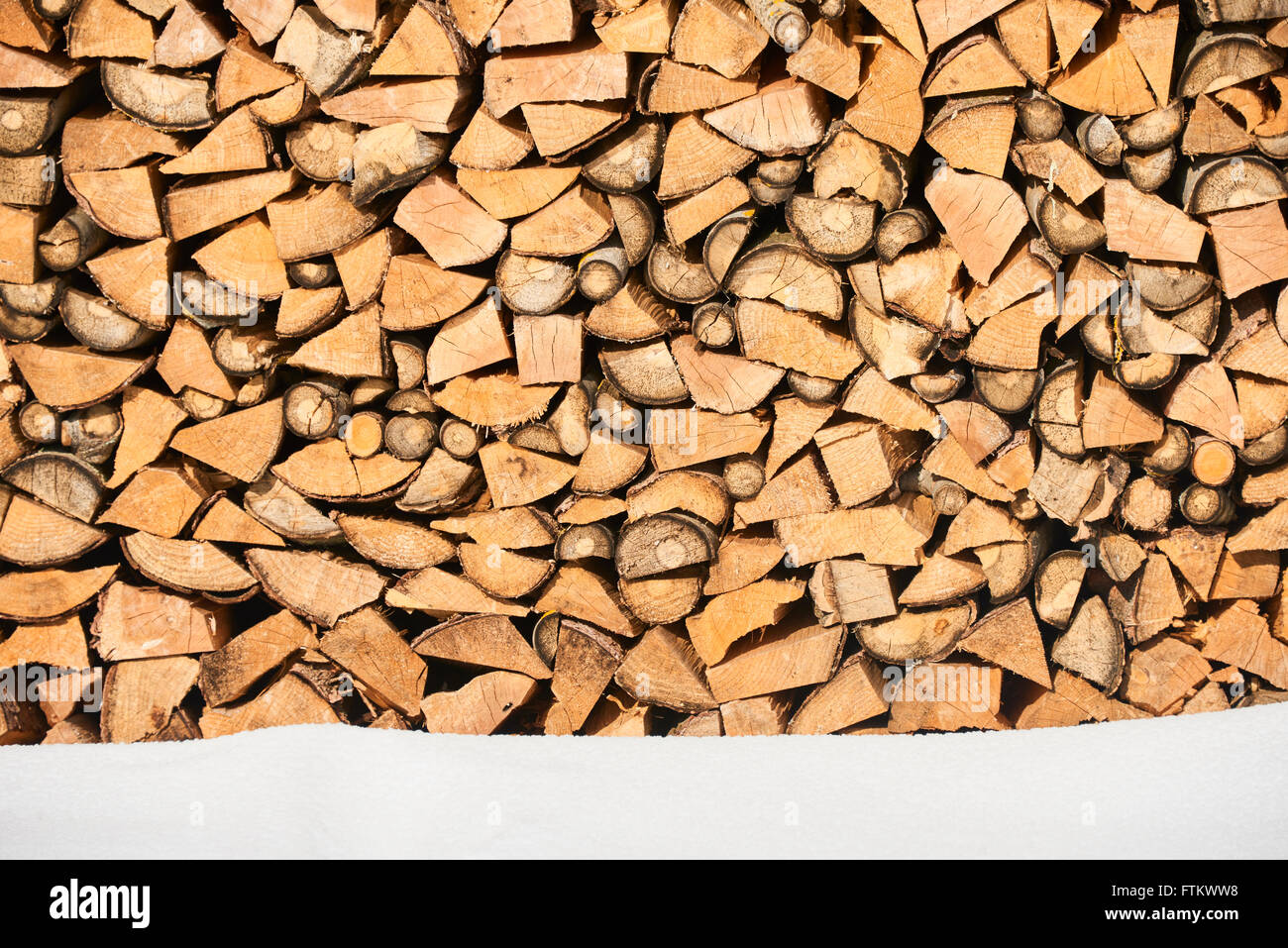 Firewood stacked in winter. Wood pile with snow stacked for firewood ...