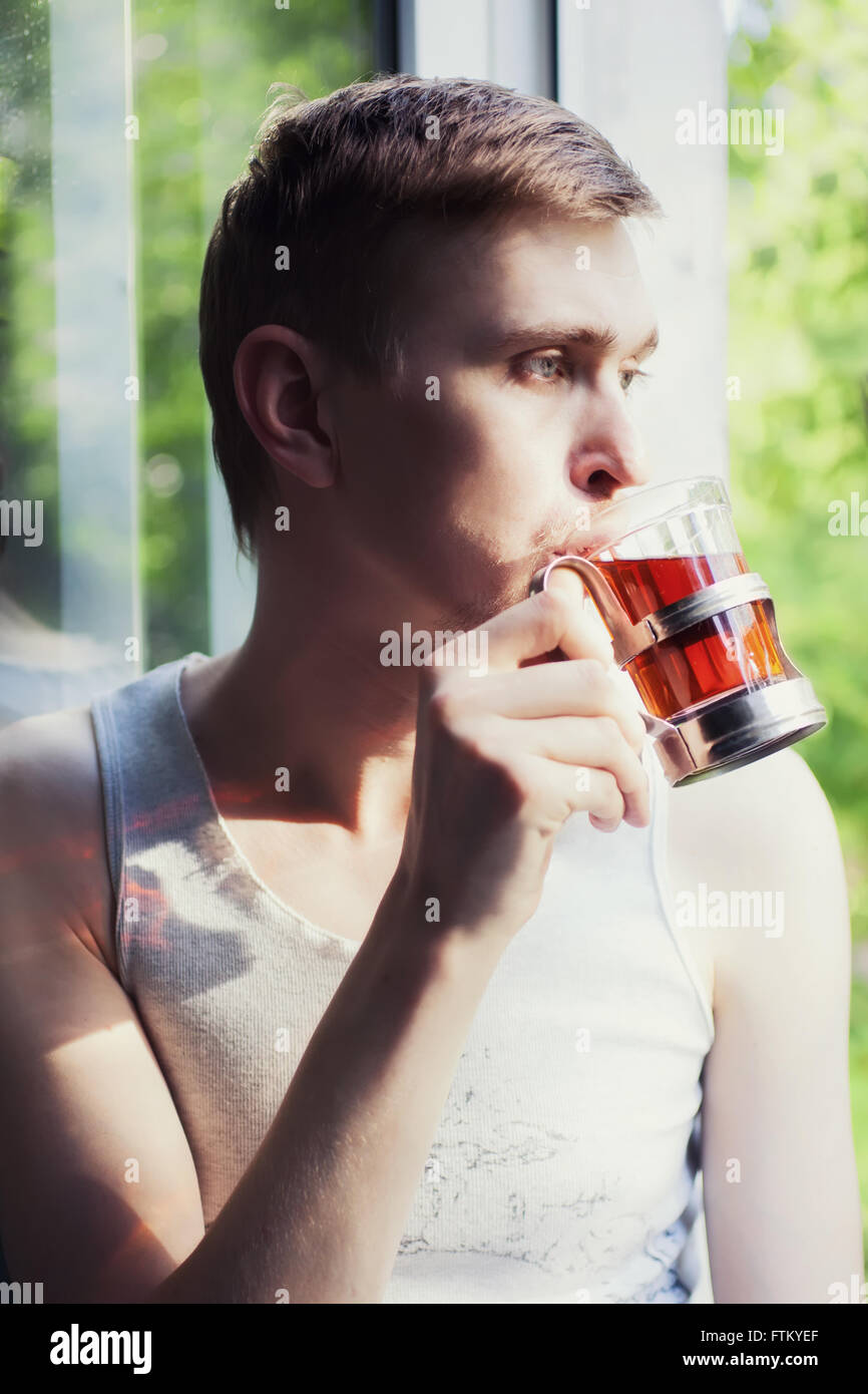 Portrait of young man drinking tea near the window Stock Photo - Alamy
