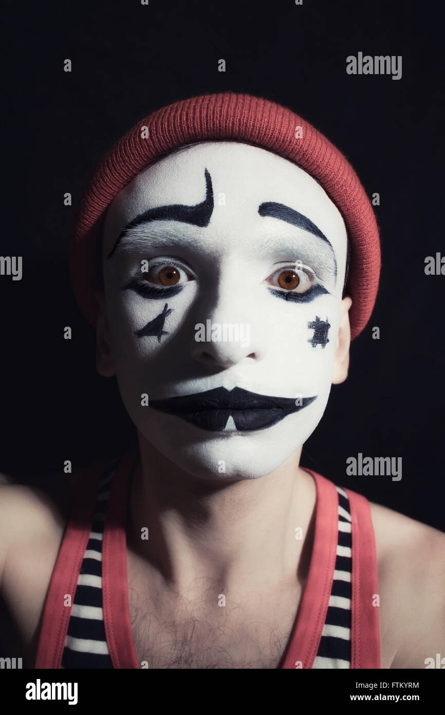 Portrait of sad mime wearing hat on black background Stock Photo - Alamy
