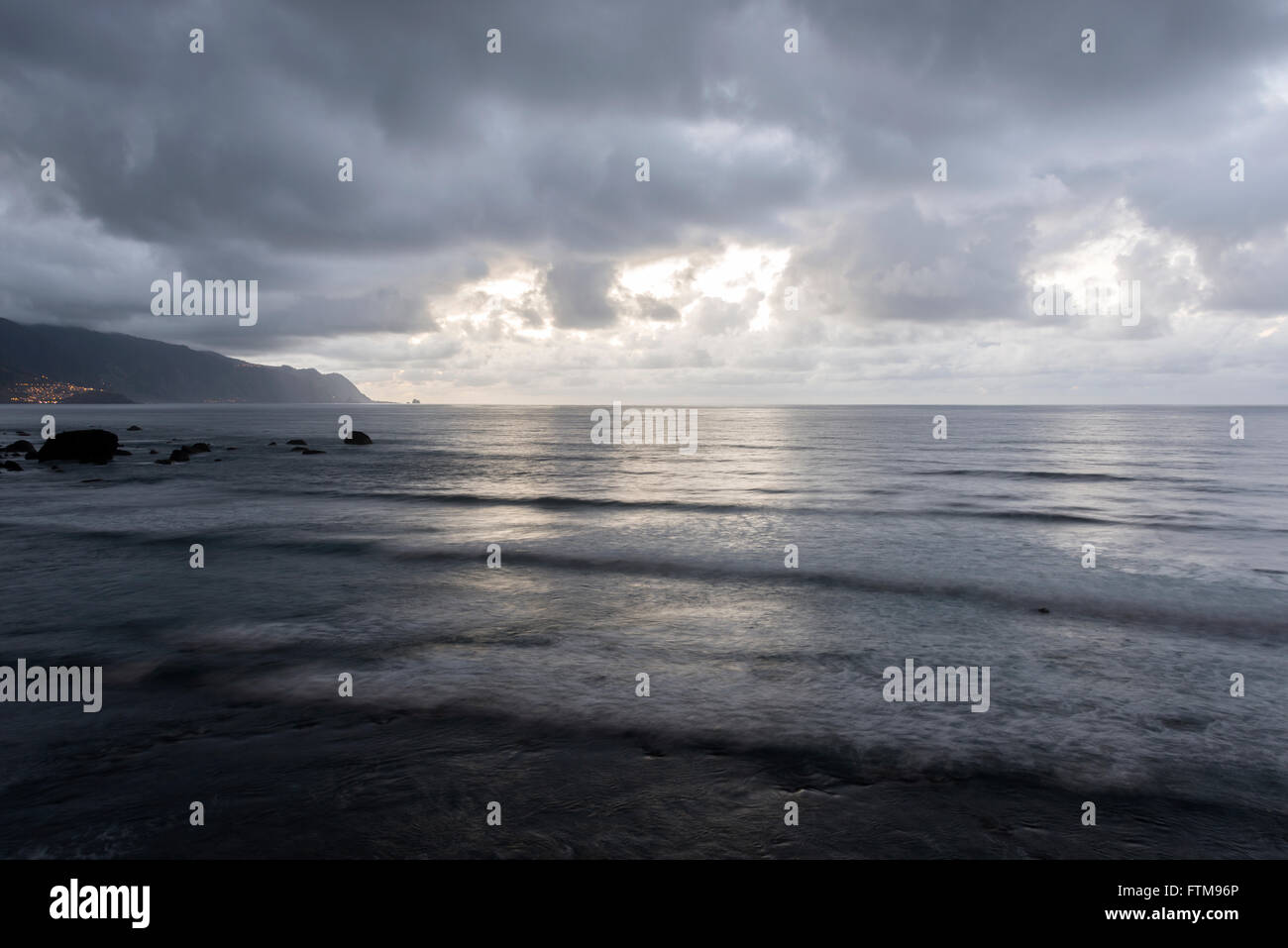 dark clouds in the evening over Madeira island with clouds and rocks ...