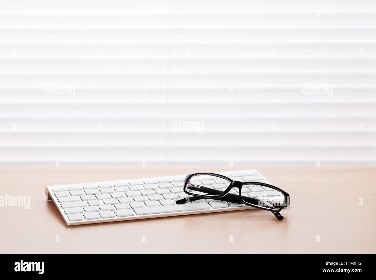 Office workplace with pc keyboard and glasses on wooden desk table in ...