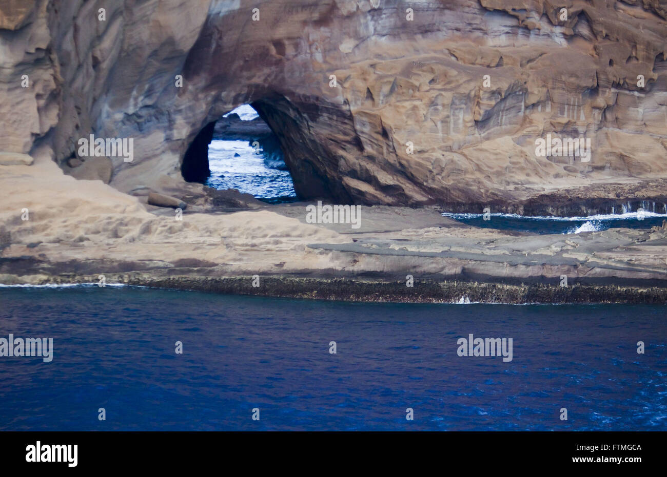 Volcanic rock pierced by the force of the water on the island of ...