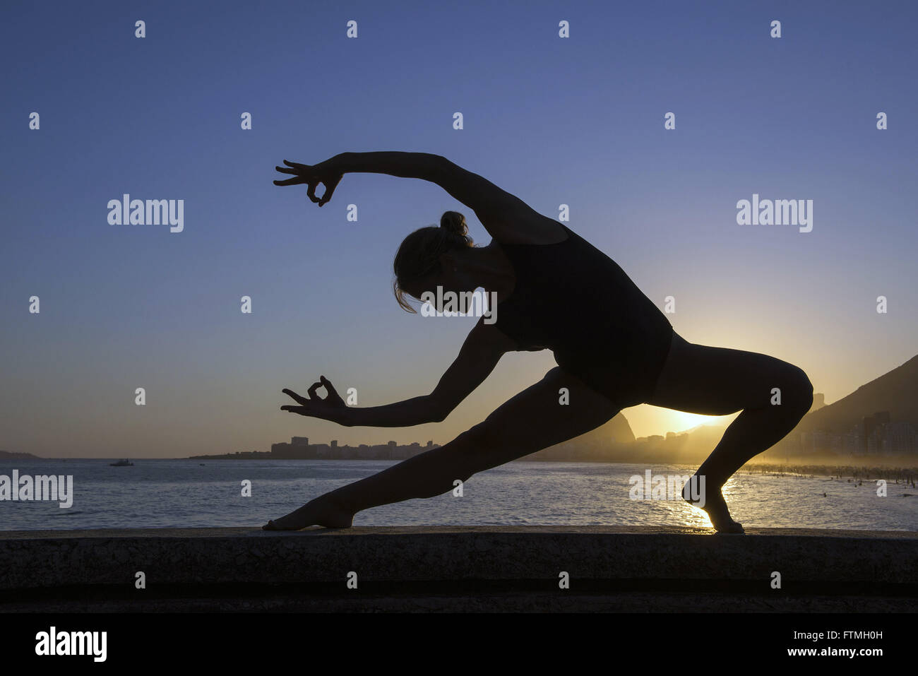 Woman May in yoga pose in Leme Beach - south Stock Photo - Alamy