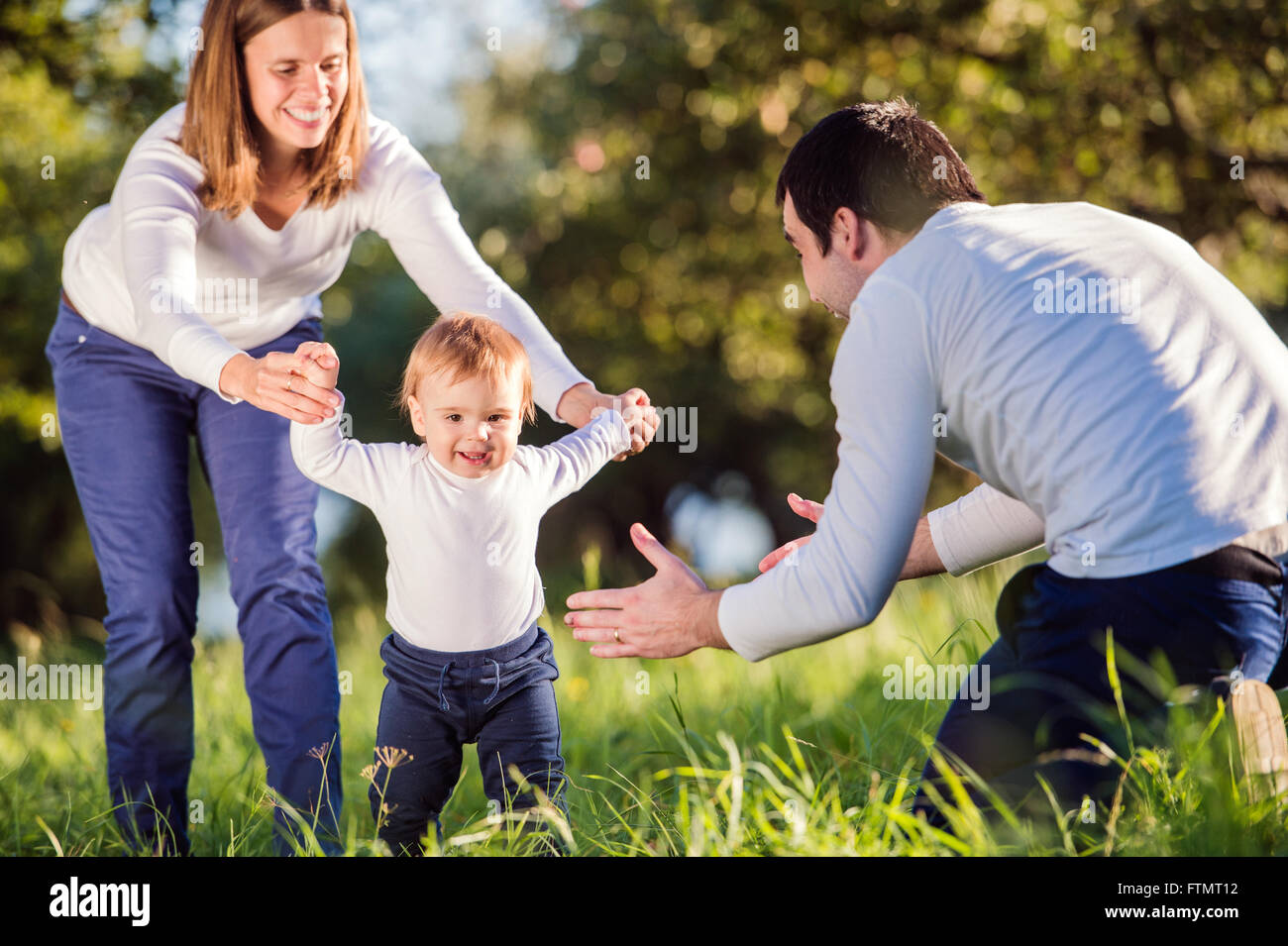 Parents holding their little son making first steps Stock Photo - Alamy