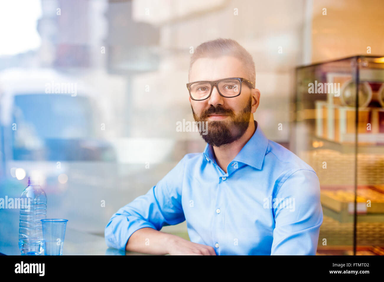 Hipster manager sitting in cafe by the window, reflection Stock Photo ...