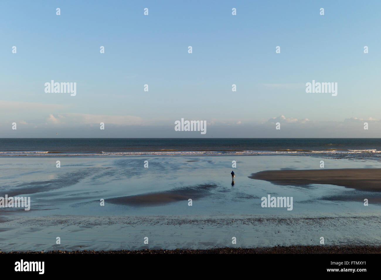 Solitary shrimp fisherman walking on empty beach, Normandy, France ...