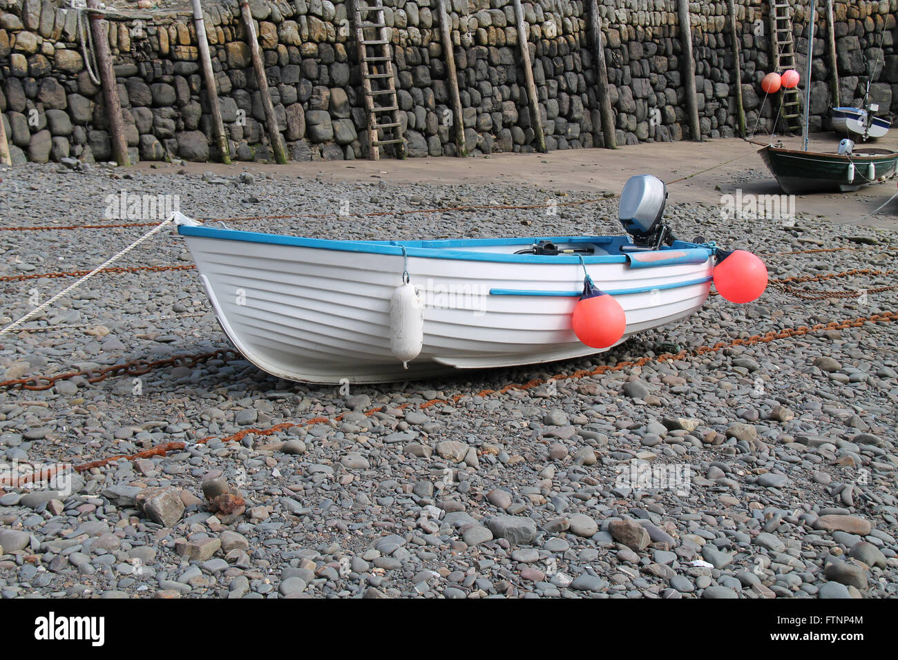 A Small Motor Boat Resting on a Dry Harbour Floor Stock Photo - Alamy