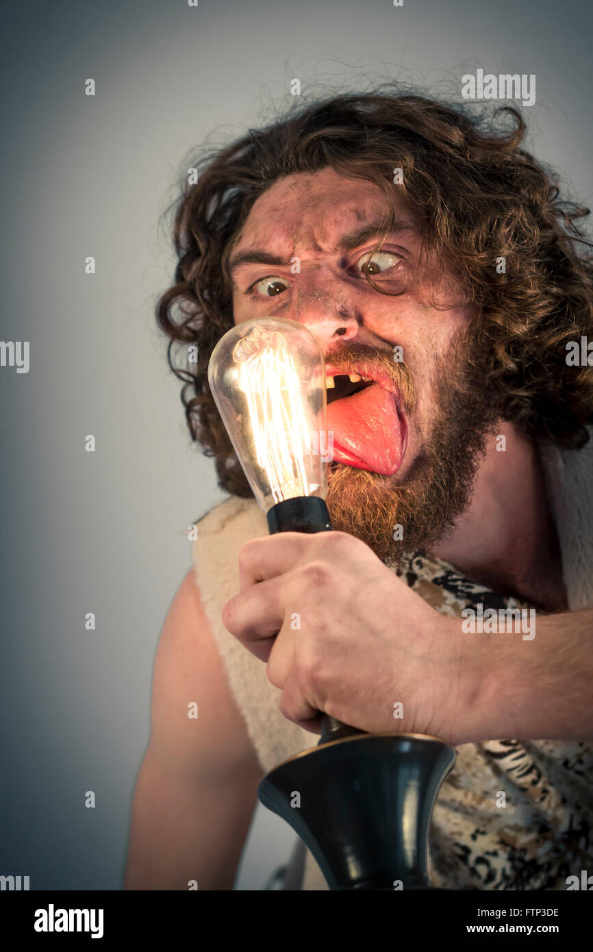 Silly realistic caveman dumbfounded by confusing edison lightbulb Stock ...