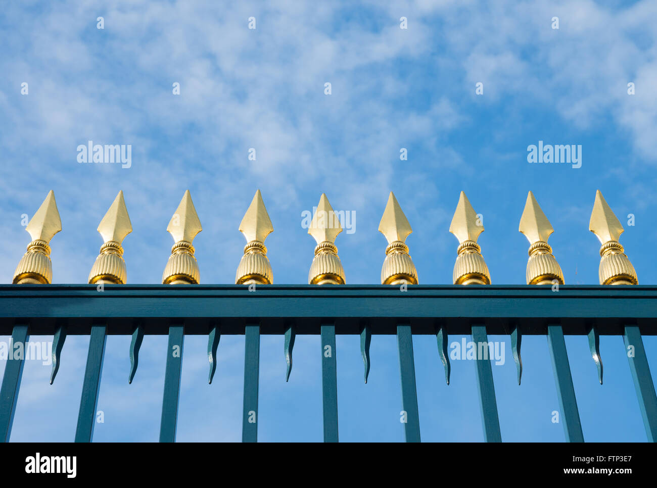green metal gate with decorative golden spikes Stock Photo - Alamy