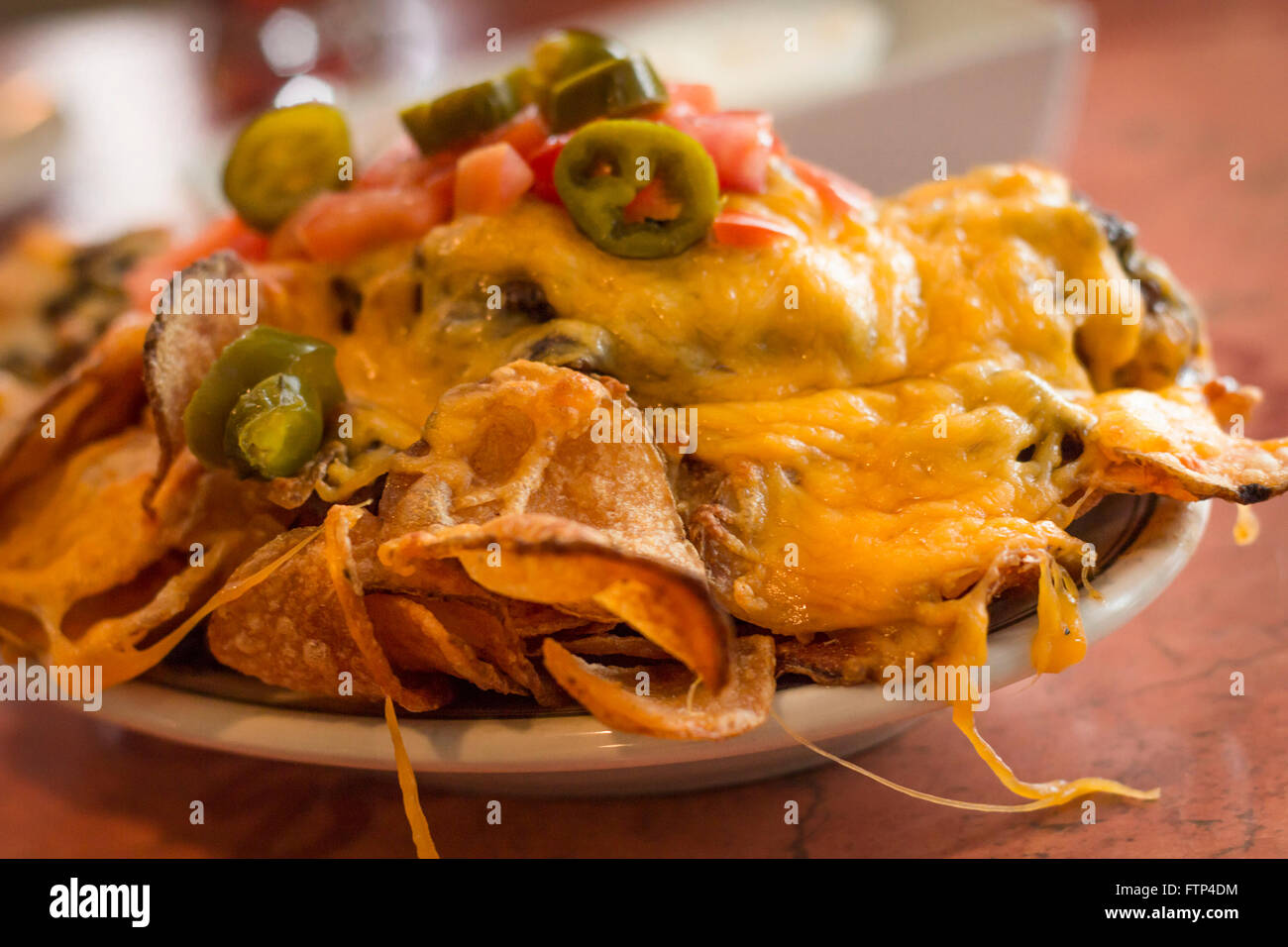 Loaded potato nachos with melted cheddar cheese Stock Photo - Alamy