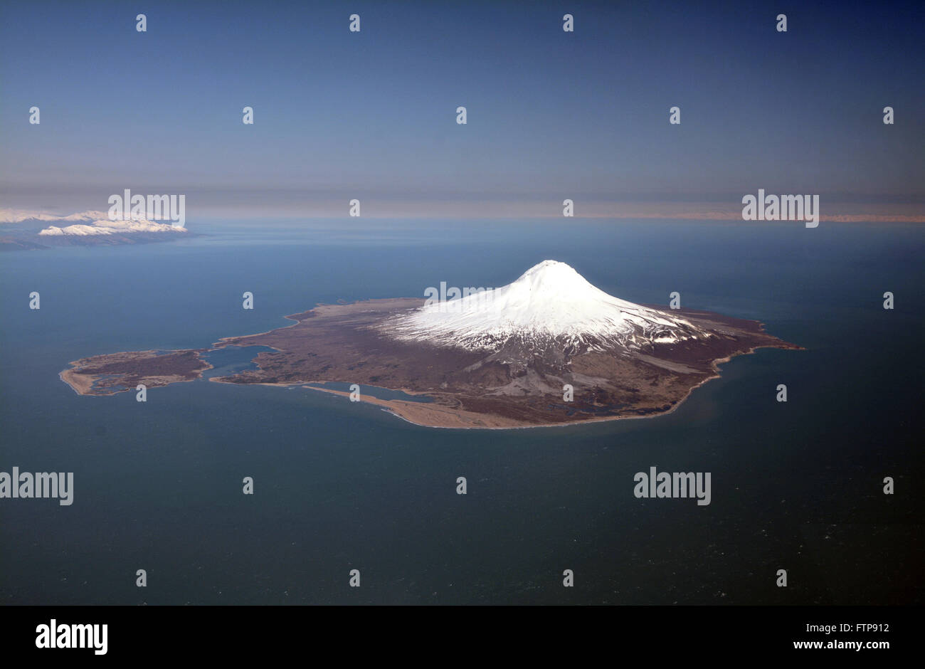 The snow capped cone of the Augustine Volcano on Augustine Island in ...