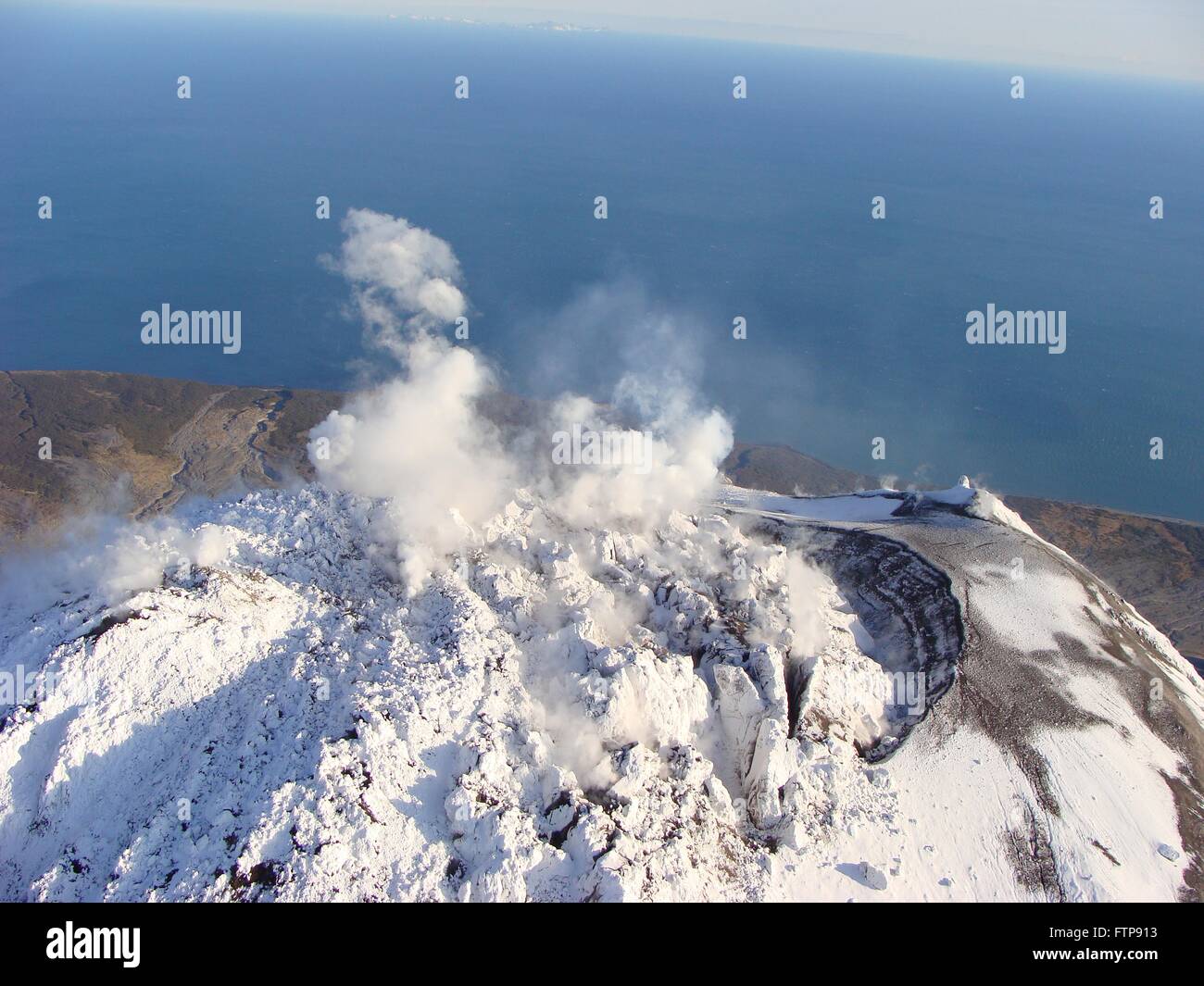 Steam rises from the snow-covered lava dome at the summit of Augustine ...