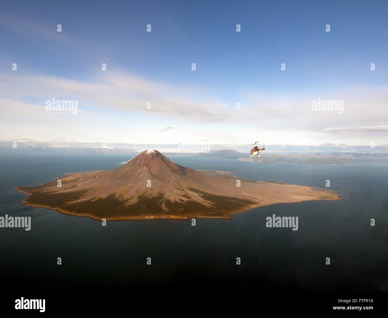 A helicopter approaches the Augustine Volcano carrying a team of ...