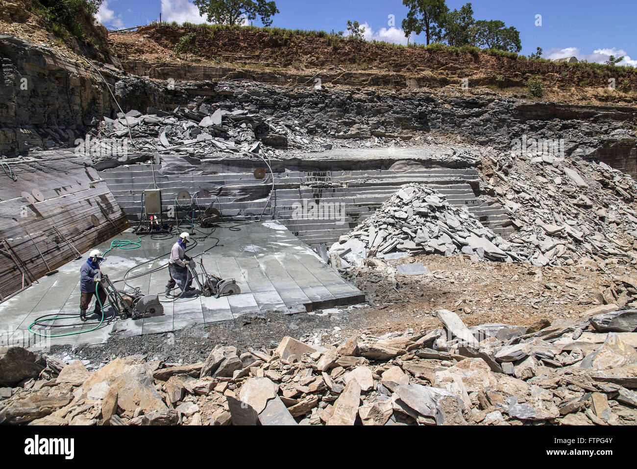 Workers cutting rock in mining digging slate waste and cut around the ...