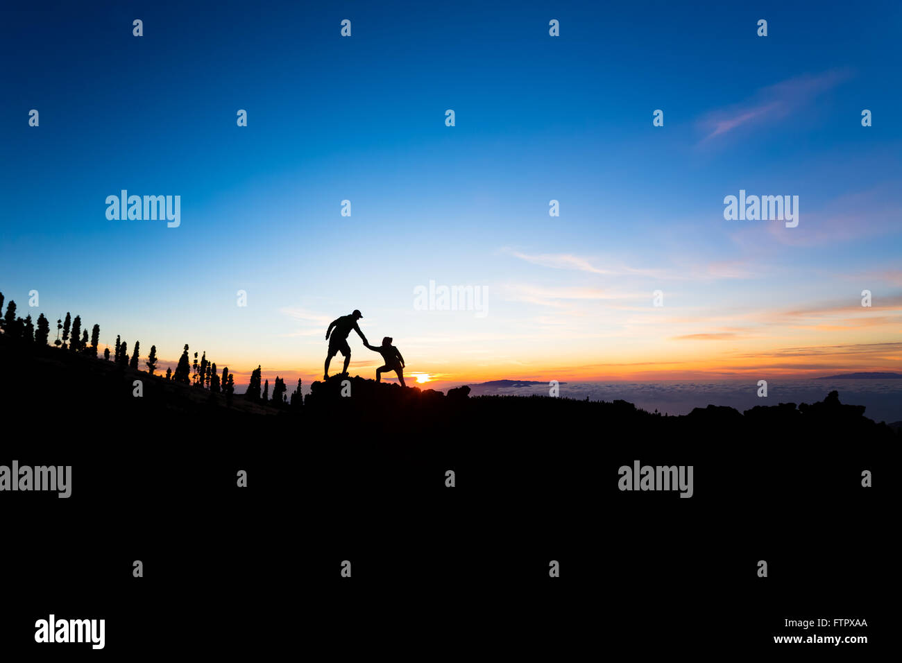Silhouette man helping woman climb hi-res stock photography and images ...